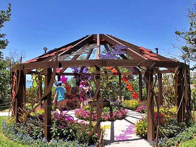 A rainbow of blooms bursts from this garden pavilion, where visitors wander through living color under an architectural canopy.