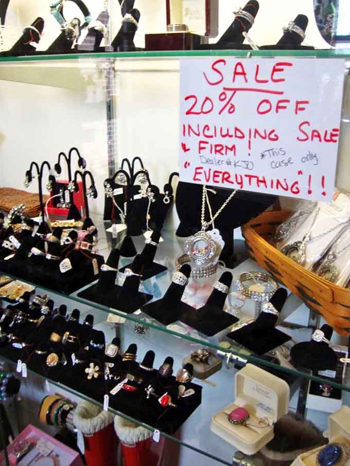 Jewelry displays glitter under careful lighting, while a handwritten sale sign adds that personal touch missing from corporate retail.