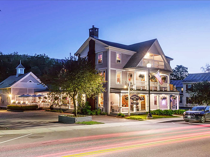 The Old Stagecoach Inn stands illuminated against the evening sky, promising sweet dreams and even sweeter breakfast – the kind worth setting an alarm for.