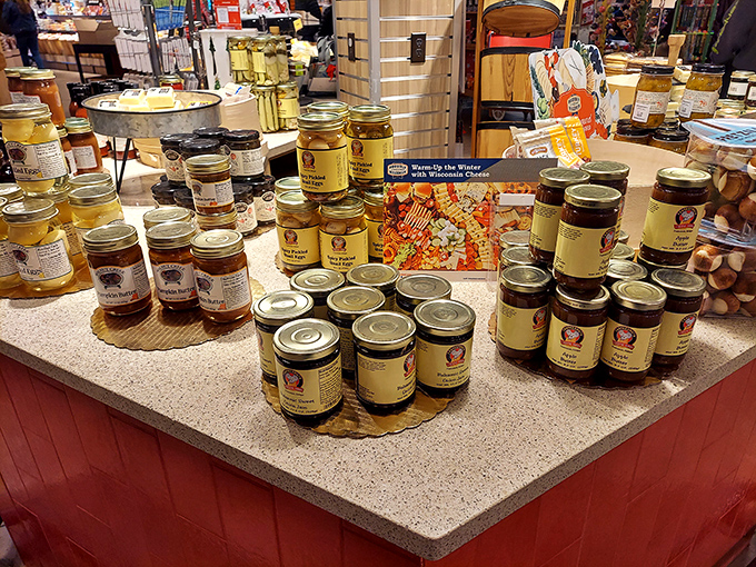 Jars of preserves, jellies, and specialty condiments create a colorful display. These aren't just toppings – they're flavor transformers for your cheese board.
