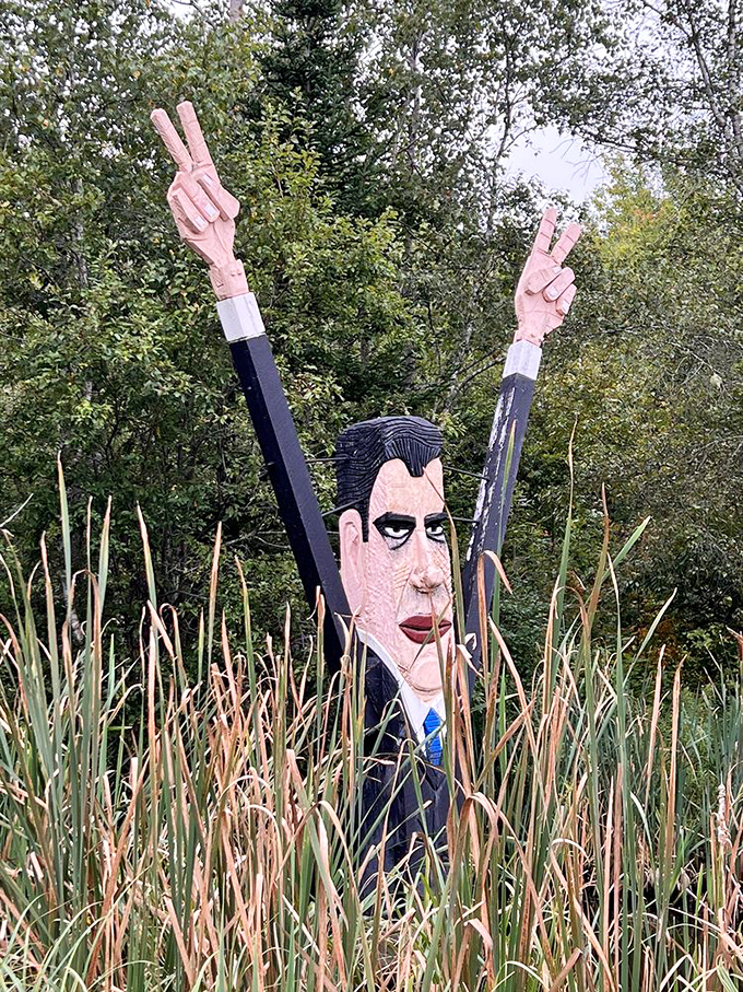 A political figure emerges triumphantly from tall grasses, arms raised in victory, creating an unexpected and slightly surreal woodland encounter.