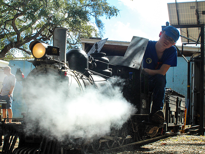 Steam billows dramatically as a volunteer tends to locomotive #90, demonstrating the authentic operations that make these miniatures magical.