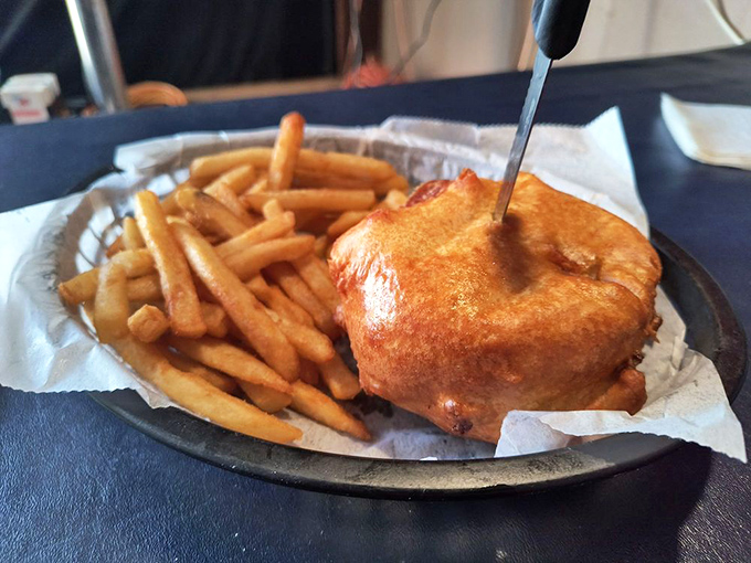 The Triple D Burger arrives like a skyscraper of flavor &ndash; a half-pound patty wearing an onion ring "hat." This is architecture you can eat.