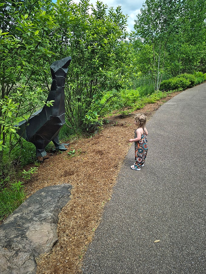 Art meets nature with this striking sculpture, capturing a young visitor's curiosity against a backdrop of lush Vermont greenery.
