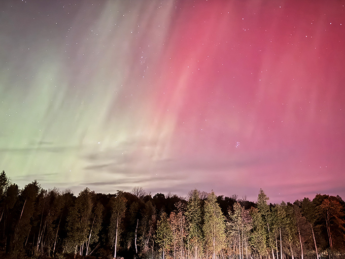 The Northern Lights dance across the horizon, nature's own light show that makes Las Vegas look like amateur hour.