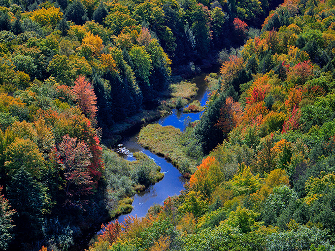 The Carp River winds through the valley below, adding another element to the already stunning landscape composition.