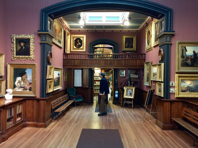 The massive landscape painting dominates the room like it owns the place, which, let's be honest, it kind of does.