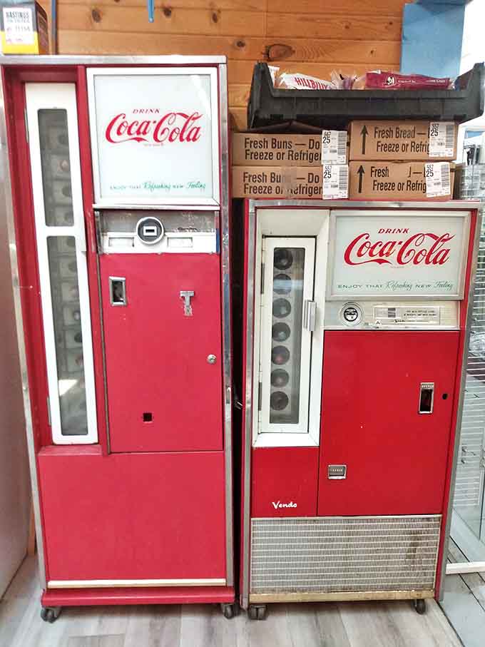 Vintage Coca-Cola machines stand as red-painted sentinels of simpler times, when the hiss of a bottle opening was the soundtrack to summer afternoons.