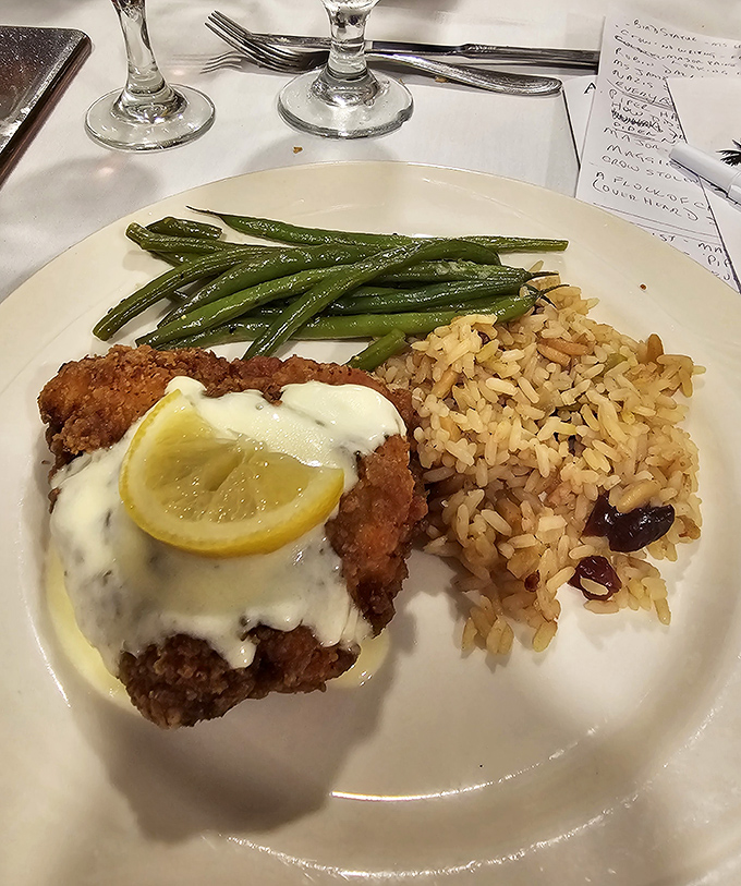 Breaded chicken francese glistens with light lemon sauce, accompanied by rice pilaf and green beans &ndash; brain food for mystery solvers.