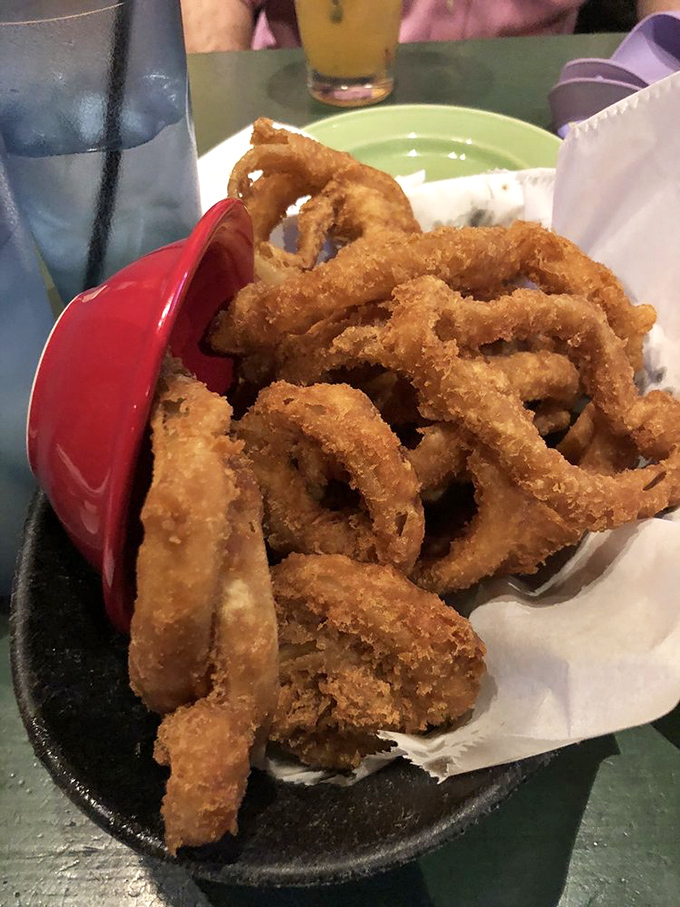 Golden onion rings piled high like crispy halos &ndash; the perfect sidekick to any main dish or worthy of attention all on their own.