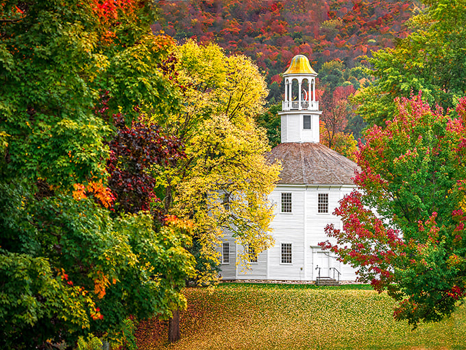 Autumn transforms the church's surroundings into a painter's palette of reds and golds, nature's perfect complement to the white clapboard structure.
