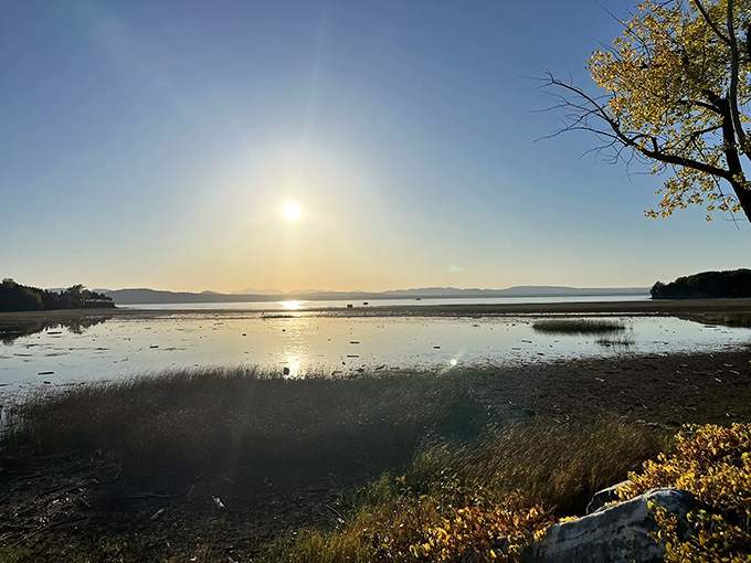 Golden hour casts its magic spell across Malletts Bay &ndash; when photographers line the causeway for that perfect Vermont sunset shot.