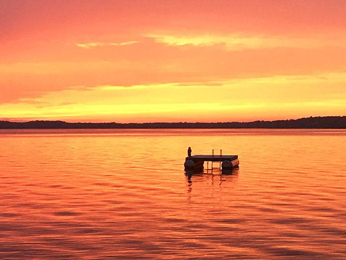 Sunset transforms Torch Lake into liquid gold. As day fades, the water mirrors the sky's fiery display in a twice-as-nice visual feast.