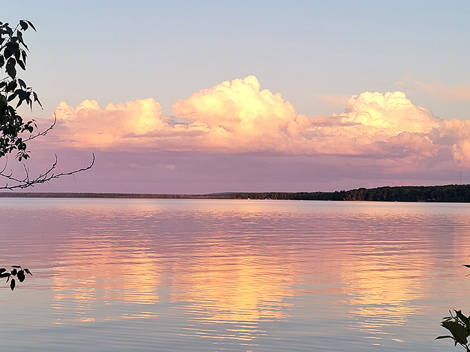 Lake Independence mirrors cotton candy clouds at sunset &ndash; nature showing off its photography skills without a single filter needed.