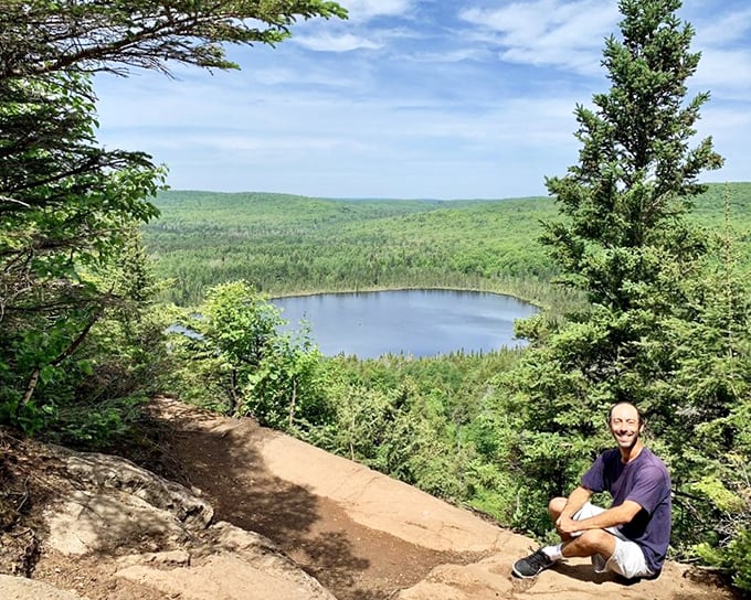 Hikers pause to absorb the breathtaking vista, where Oberg Lake gleams like a dropped coin in nature's pocket.