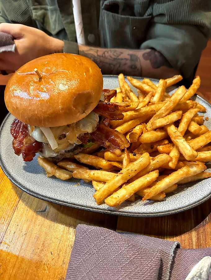 The Black Sheep burger arrives like a flavor bomb on a plate &ndash; juicy beef, crispy bacon, and golden fries demanding immediate attention.