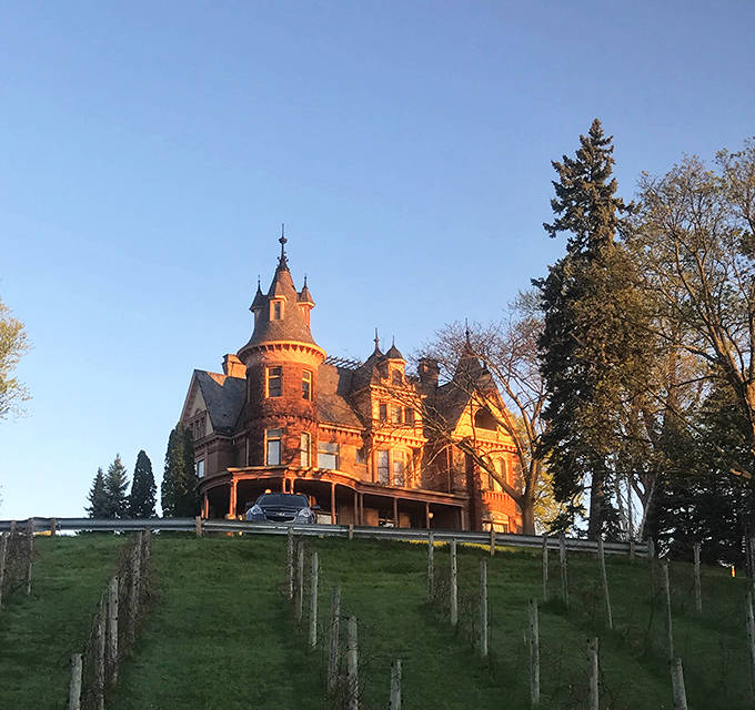 Henderson Castle glows with sunset warmth, its hilltop position and dramatic turrets creating a romantic silhouette above Kalamazoo.