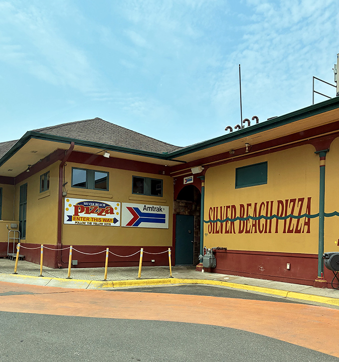 Silver Beach Pizza's sunny yellow exterior occupies a historic Amtrak station, where diners enjoy pies with a side of Lake Michigan views.