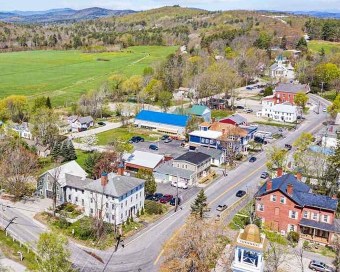 An aerial view of Limerick reveals a community nestled among trees and hills, creating a picturesque Maine landscape throughout all seasons.