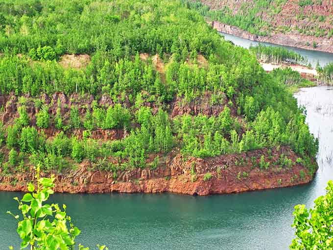 The massive scale of human ambition reveals itself in Rouchleau Mine's deep walls, now softened by water and returning greenery.
