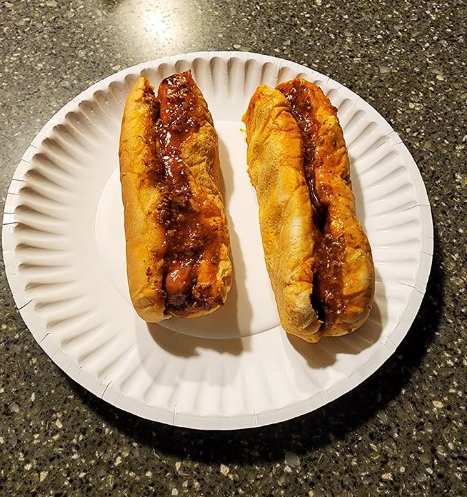 Two ambassadors of comfort food perfection, where the humble hot dog meets its destiny under a blanket of house-made chili.