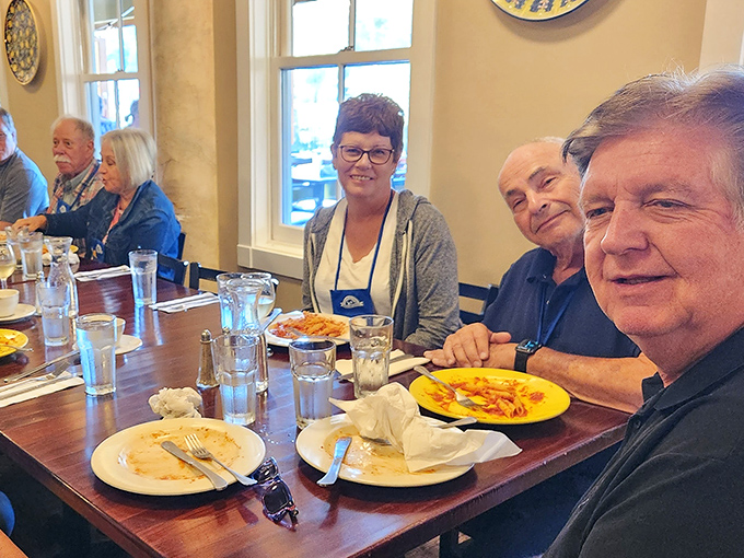 Happy diners sharing stories and pasta &ndash; the universal language of "this food is too good not to share."