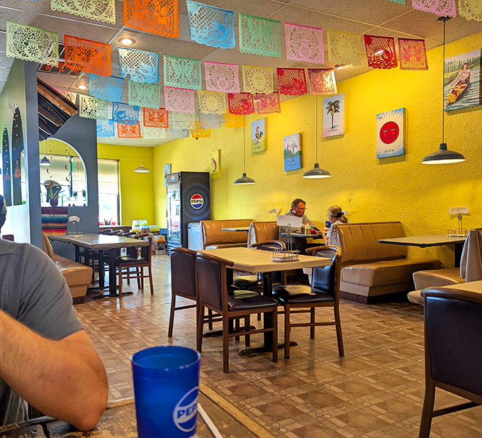 Colorful papel picado banners turn an ordinary dining room into a space that feels festive without trying too hard to impress you.
