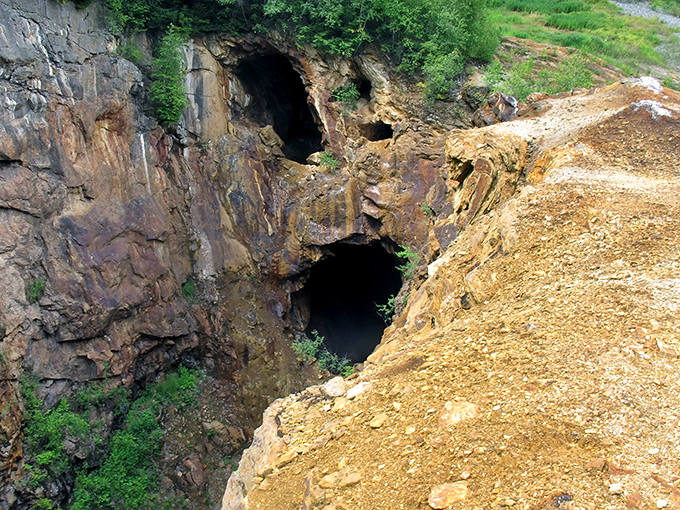 Dark mine entrances hint at the underground world where generations of miners worked in conditions that would make modern safety regulations weep, now silent monuments to a vanished industrial era.