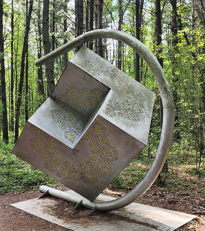 This majestic metal elk stands sentinel by the water, its reflection creating a perfect moment of symmetry between art and nature.