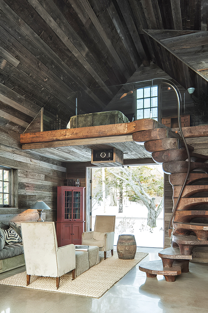 Rustic wooden walls embrace modern comfort in this loft space, where Maine cabin tradition meets contemporary luxury.