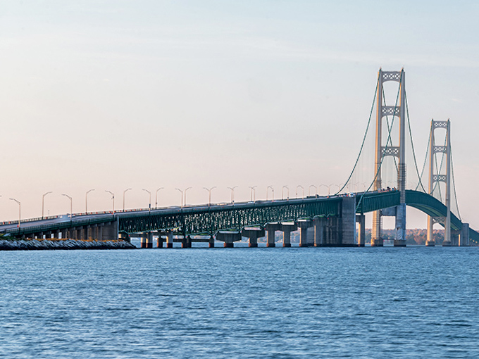 The bridge's five-mile expanse seems to stretch endlessly forward, a testament to human ingenuity conquering the powerful forces of nature below.