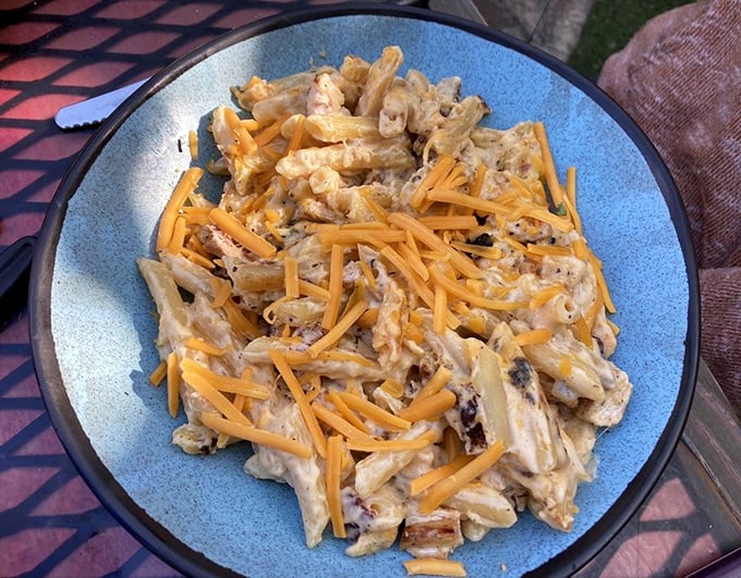 Mac 'n' cheese grows up but keeps its playful spirit &ndash; creamy pasta topped with melted cheddar that stretches with each delicious forkful.