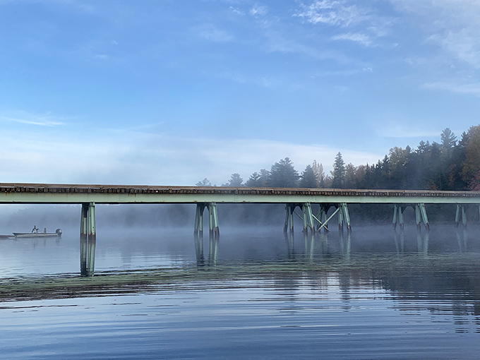 Misty morning on the waterway, where paddlers glide through reflections that double the beauty of Maine's wilderness canvas.