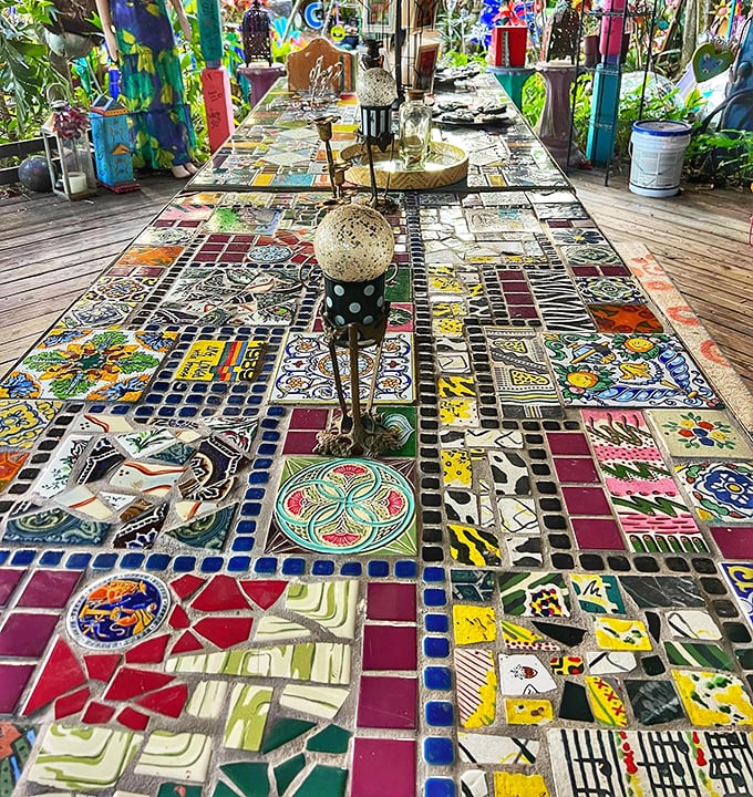 Mosaic tabletops and rainbow chairs create a gathering space where conventional furniture rules are gleefully abandoned for artistic expression.