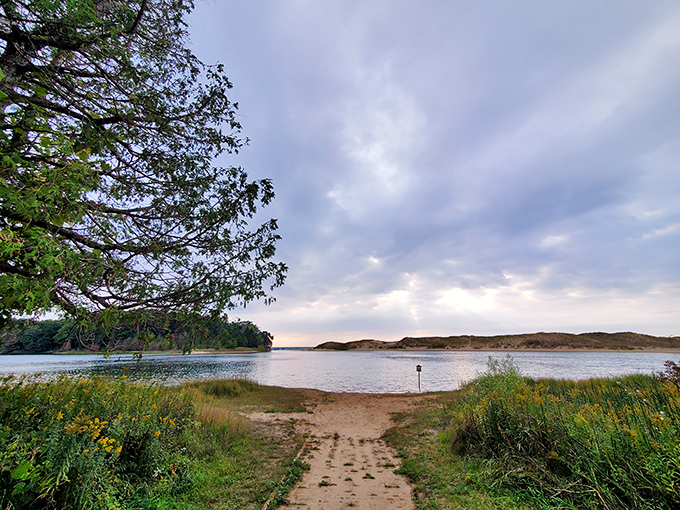 North Bar Lake's serene waters reflect dramatic skies, creating a natural mirror for Michigan's ever-changing weather.