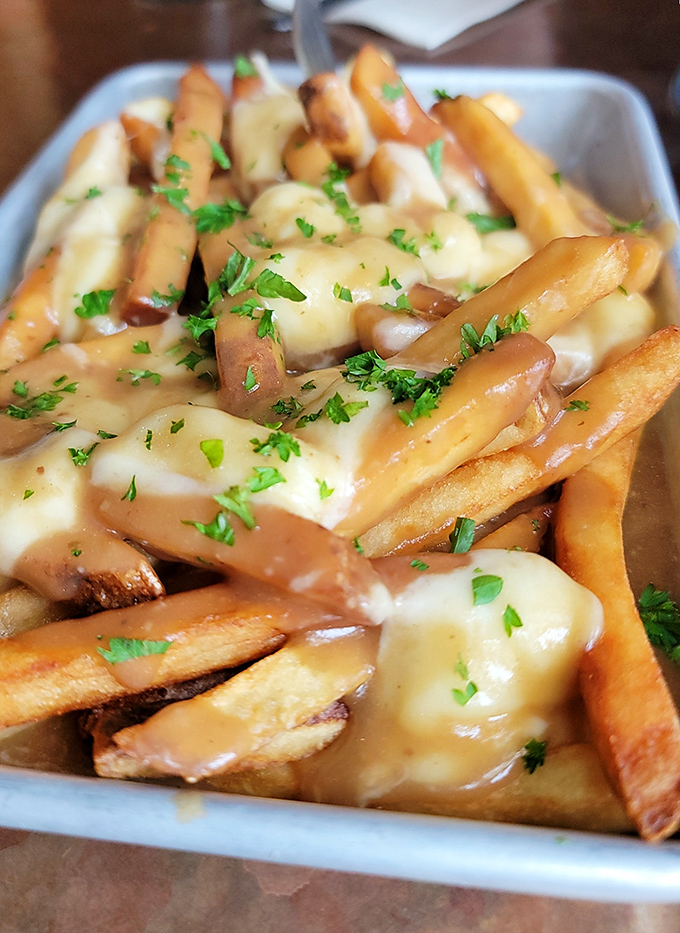 Poutine gets the Maine treatment &ndash; golden fries, melty cheese, savory gravy, and fresh herbs creating a dish that's both sophisticated and gloriously messy.