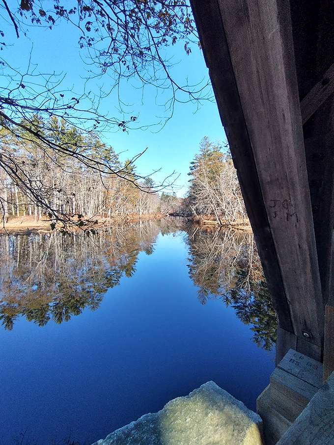 Crystal clear waters of the Saco River reflect the bridge's timeless silhouette, doubling the visual impact of this historic landmark.