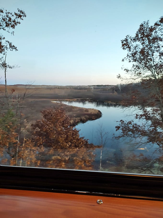 Nature puts on a show outside the train window, where still waters mirror the autumn landscape in perfect, peaceful symmetry.