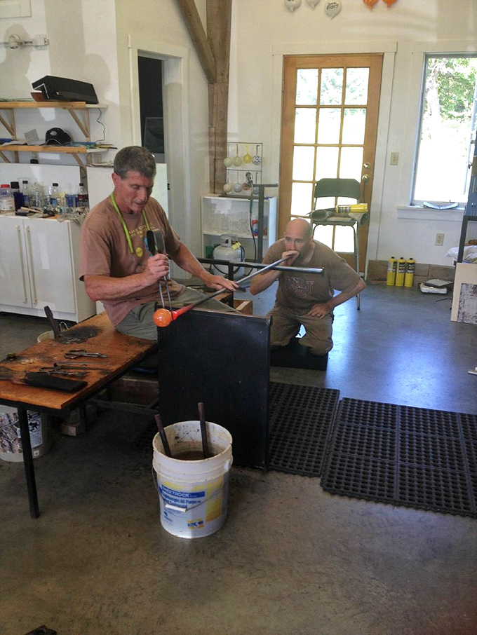 Teacher and student collaborate in the ancient dance of glassblowing, passing knowledge that spans centuries in a single session.