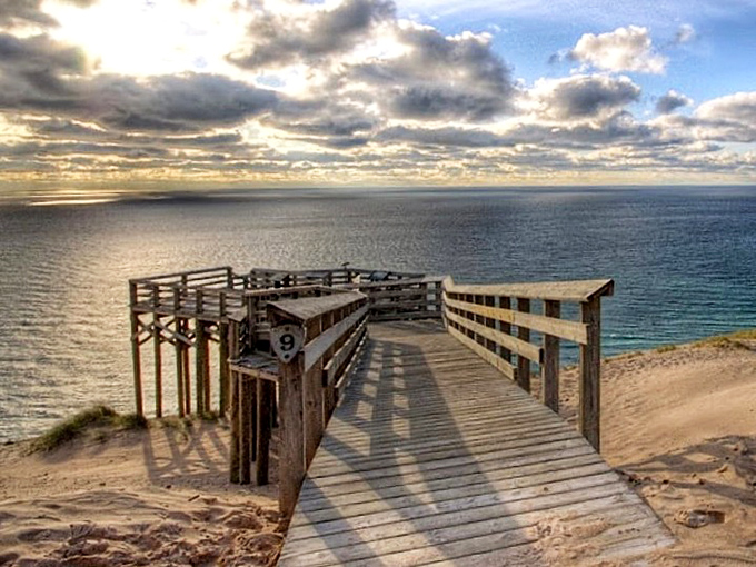 The Lake Michigan Overlook boardwalk extends like a wooden pier into thin air, offering heart-stopping views 450 feet above the turquoise waters below.