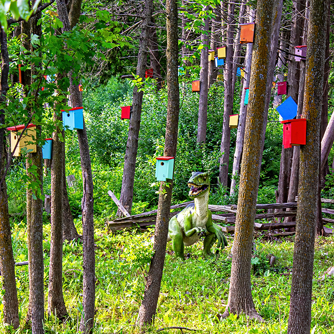 A green dinosaur surveys its domain, surrounded by tiny, colorful homes that would make any bird-watching paleontologist swoon.