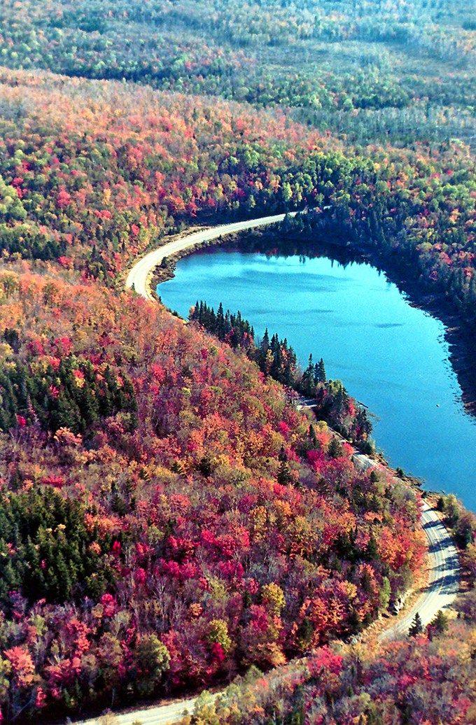Autumn colors brighten the forest as Route 17 curves gently around Beaver Pond, offering stunning views along the scenic byway.