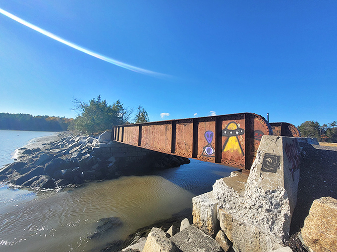 This weathered bridge stands as a rusty sentinel over the waters, connecting present-day hikers with Maine's industrial past.