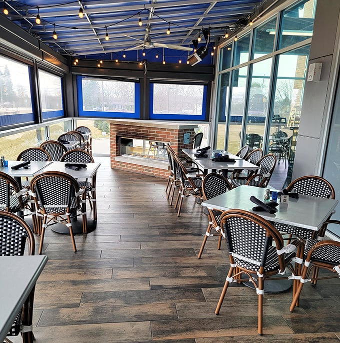 Cozy dining area: French bistro vibes with a Michigan twist – this enclosed patio space offers fireplace warmth and people-watching opportunities while you dine.