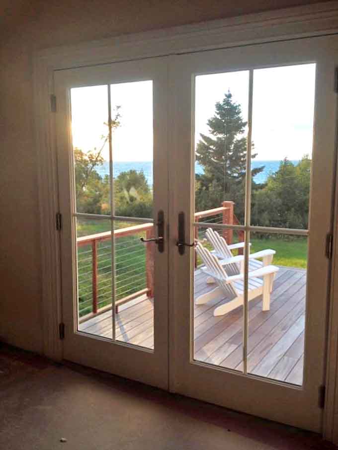 French doors frame the perfect invitation to step outside, where Adirondack chairs await your presence for morning coffee or evening contemplation.