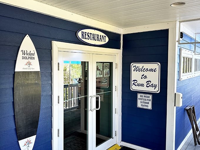 The navy blue exterior and welcoming entrance of Rum Bay Restaurant promise island adventures before you even step inside.