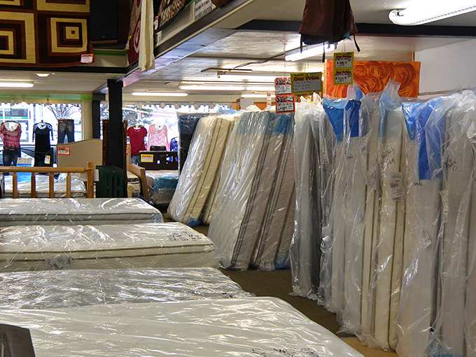 Rows of mattresses stand at attention, promising sweet dreams without the nightmare prices that keep you awake at retail stores.