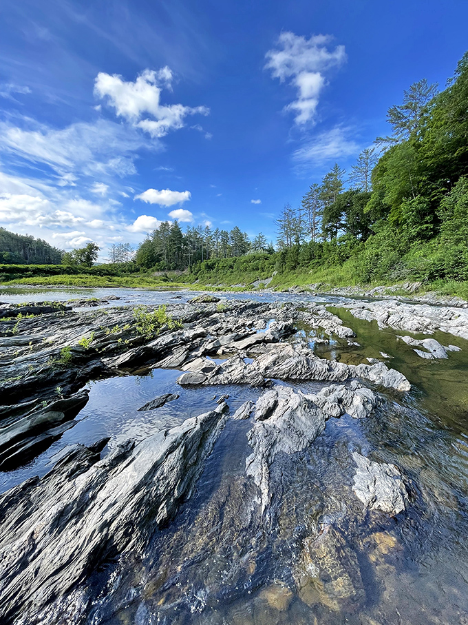 Smooth, water-polished rocks create natural platforms for visitors brave enough to venture down to the gorge floor for a different perspective.