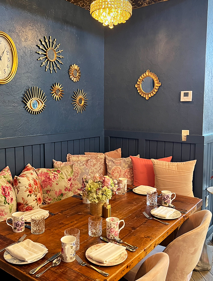 Navy walls, sunburst mirrors, and leather seating create the perfect backdrop for brunch conspiracies and weekend confessions. Grandma's china never looked this cool.