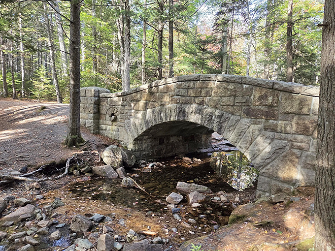 Historic stone bridge crossing a gentle stream &ndash; craftsmanship from another era, still serving hikers faithfully today.